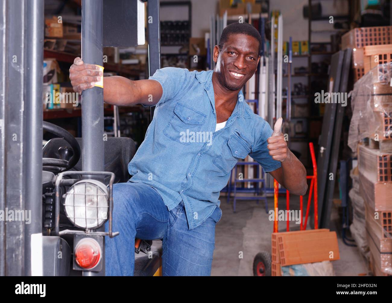 Cheerful African American worker of building materials warehouse ...