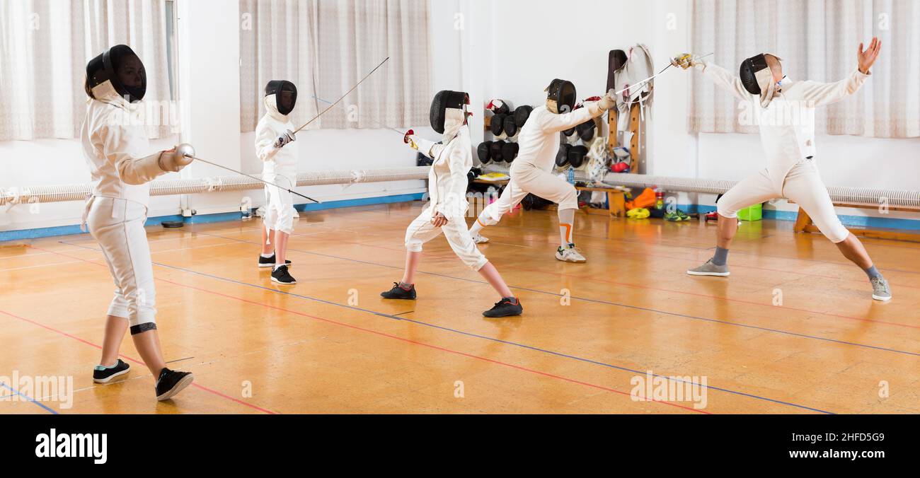 Kids with adults practicing fencing techniques Stock Photo - Alamy