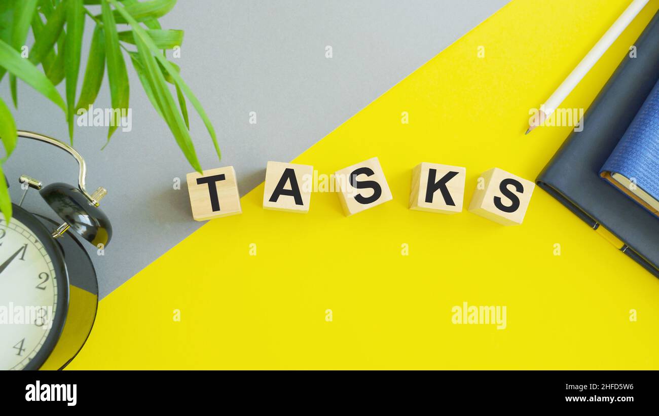Tasks symbol. The concept word tasks on beautiful yellow, gray table background. Business and ...