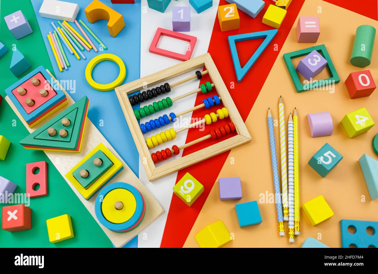 Multicolored wooden blocks on red background. Trendy puzzle toys ...