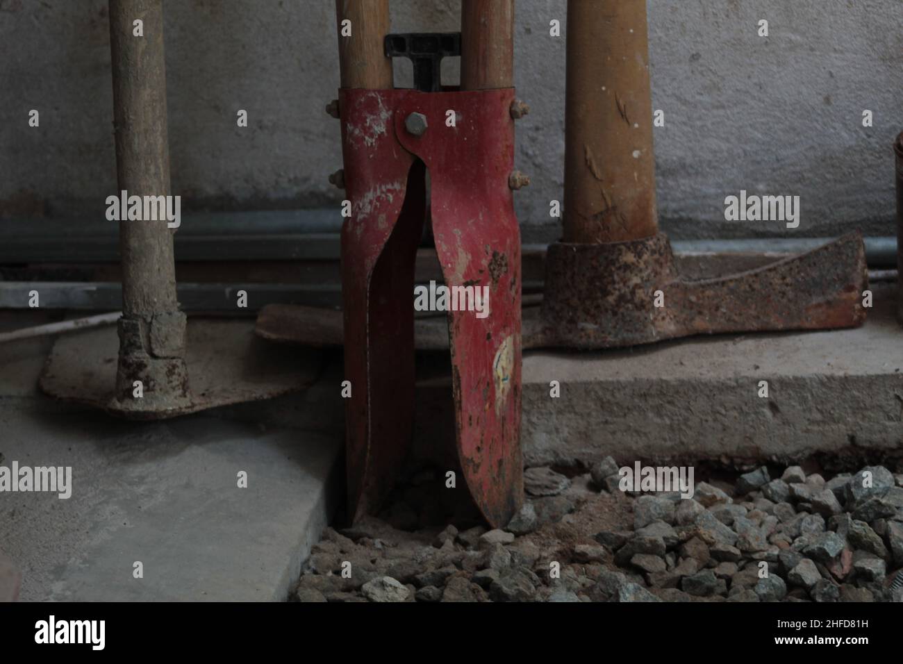 Three tools, a hoe, a pickaxe and an excavator Stock Photo - Alamy