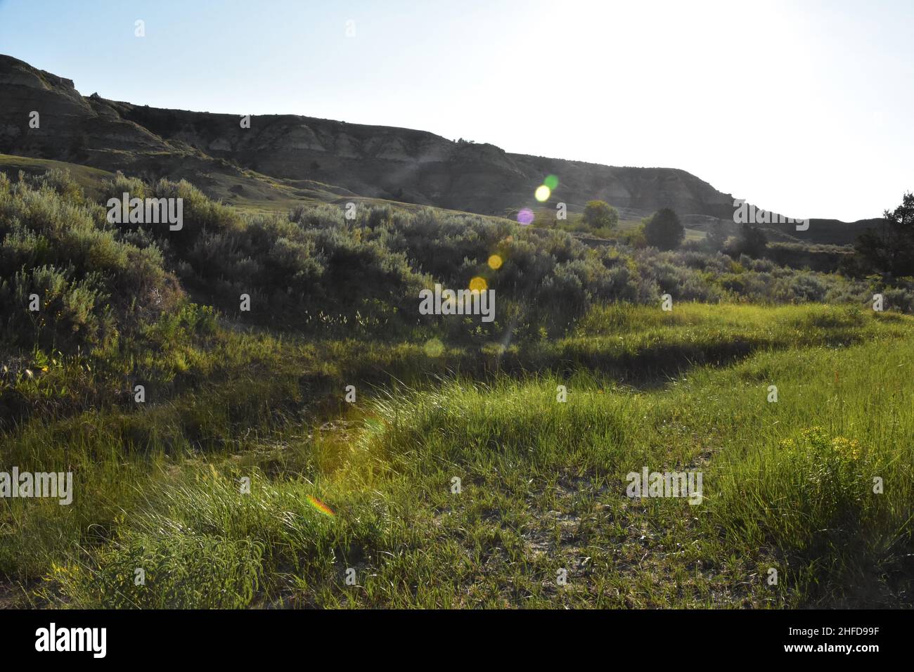 Beautiful sun rays shining on grasslands and hills in North Dakota ...