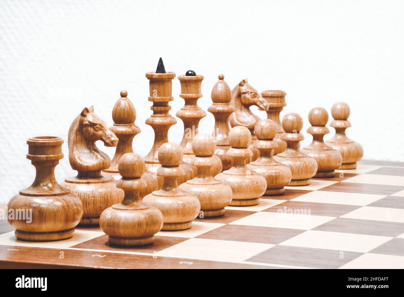 White chess pieces on the board on white background. Start position of ...
