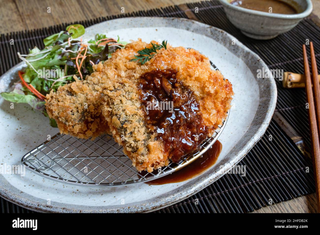 Japanese style fried fish served on a bamboo mat with chopsticks Stock ...