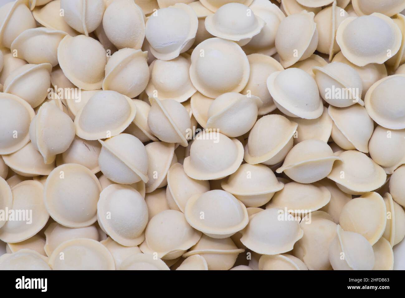 Small frozen dumplings texture background. Prepared food in the freezer ...