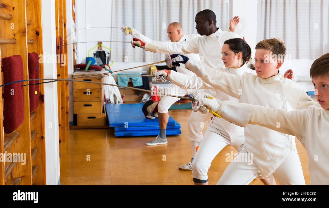 Group practicing fencing techniques in gym Stock Photo - Alamy