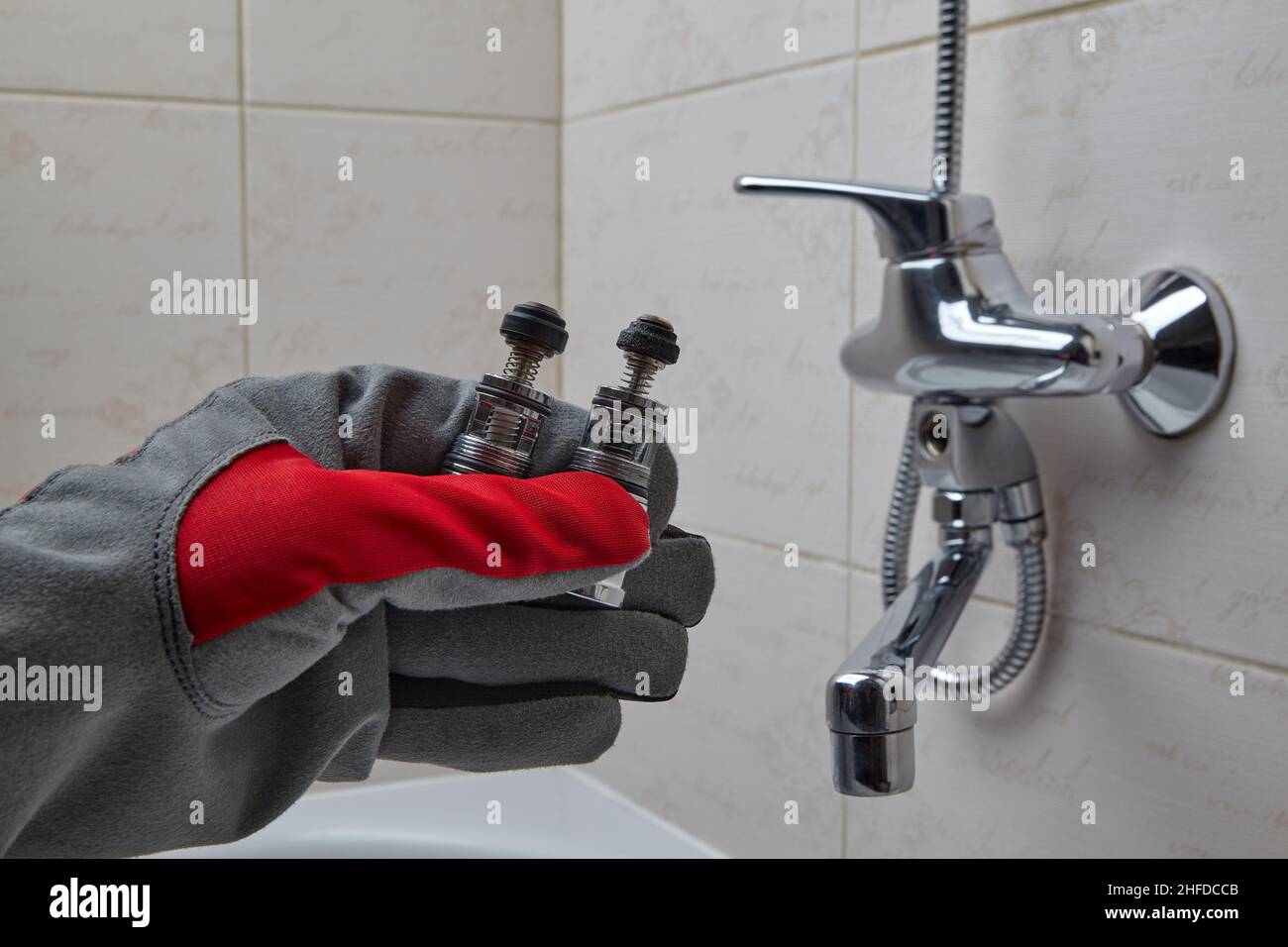 Plumber demonstrate a worn out and new shower valve switch Stock Photo ...