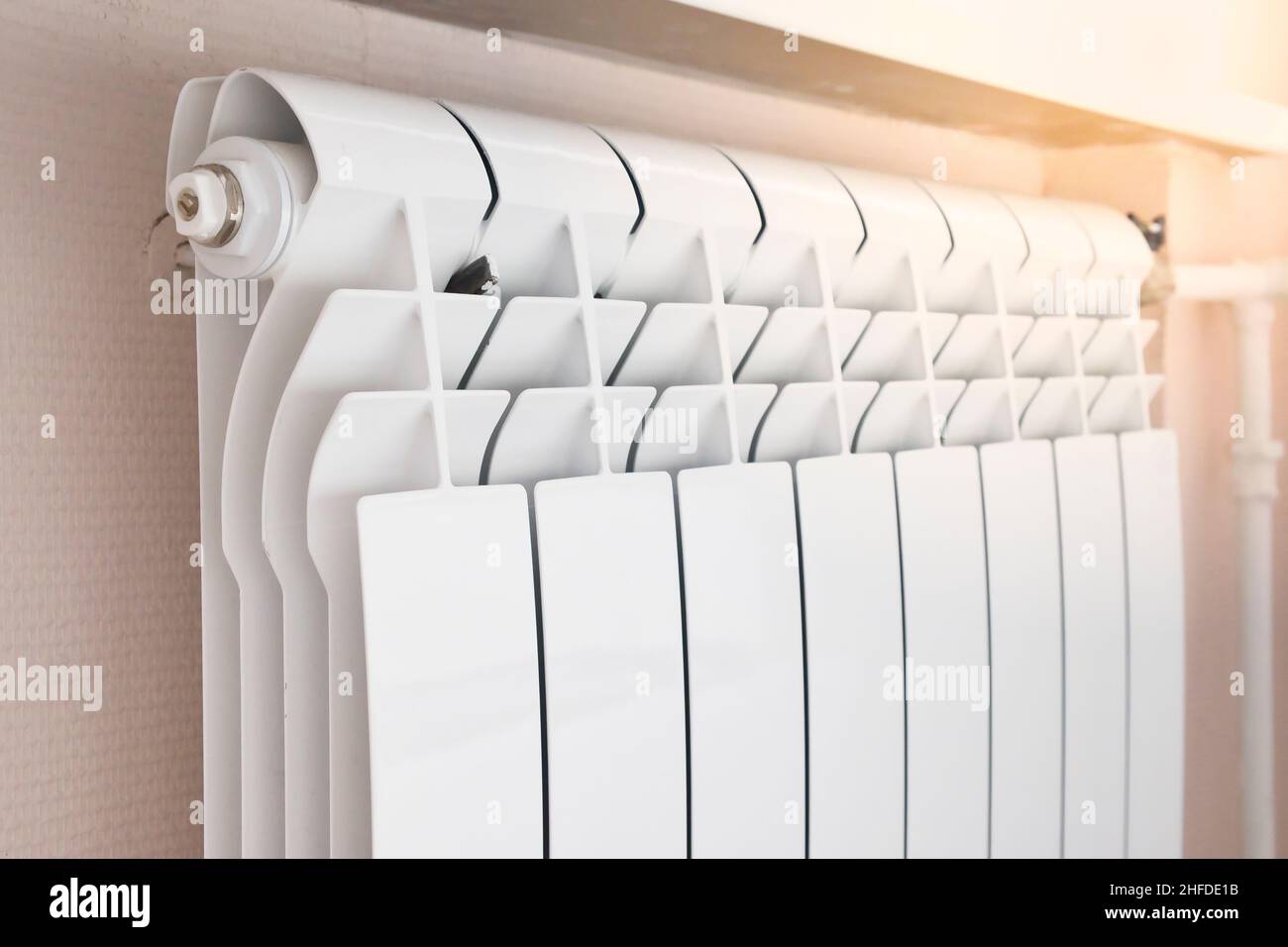 Close-up of modern home heating radiator under the window. Bimetal ...