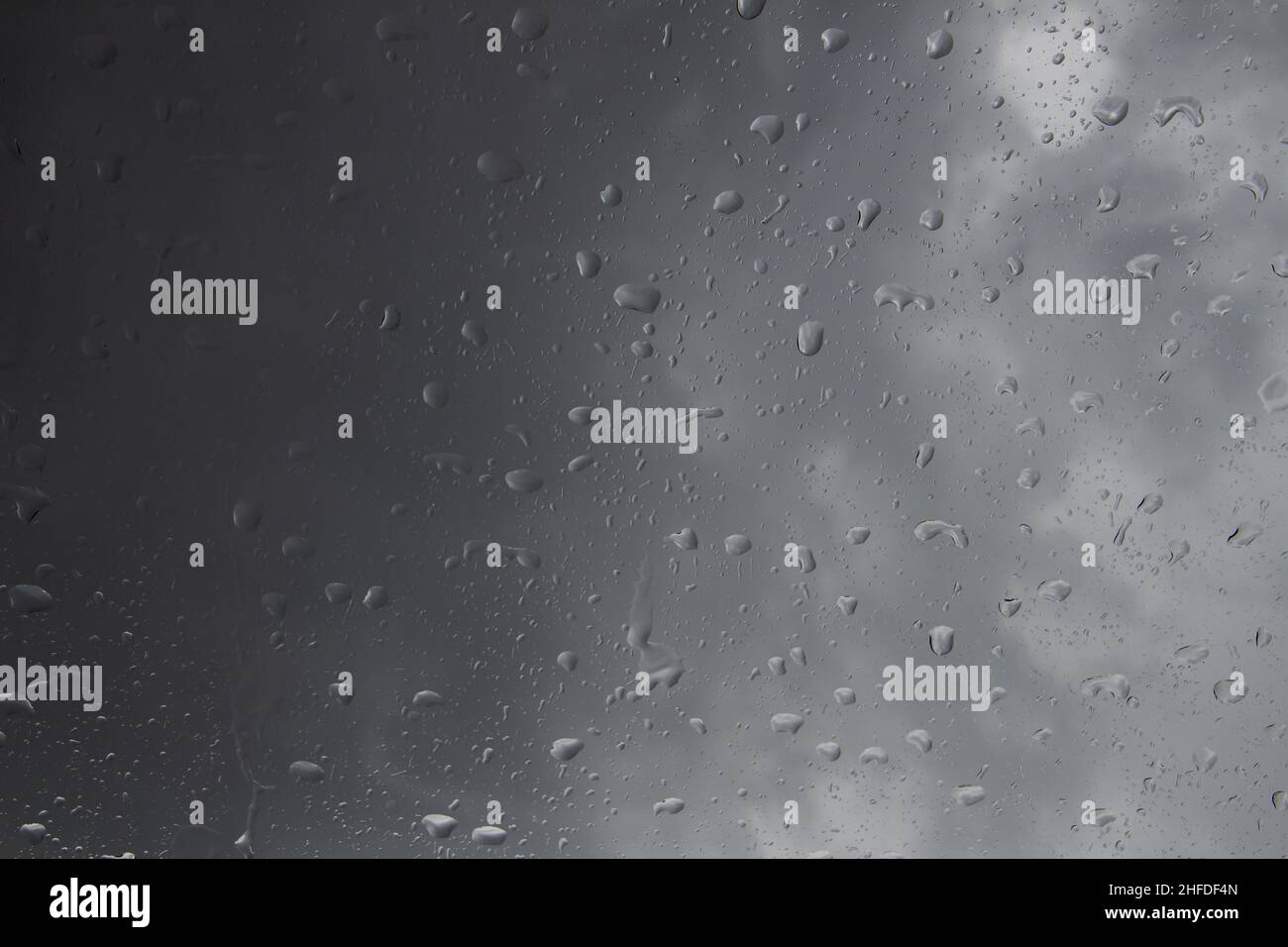 Raindrops on a window with storm clouds in the background Stock Photo ...
