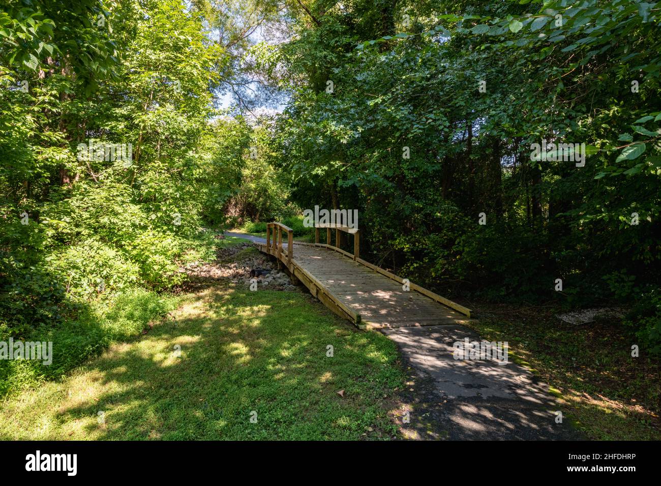 A suburban trail walkway with a wooden bridge over a creek Stock Photo ...