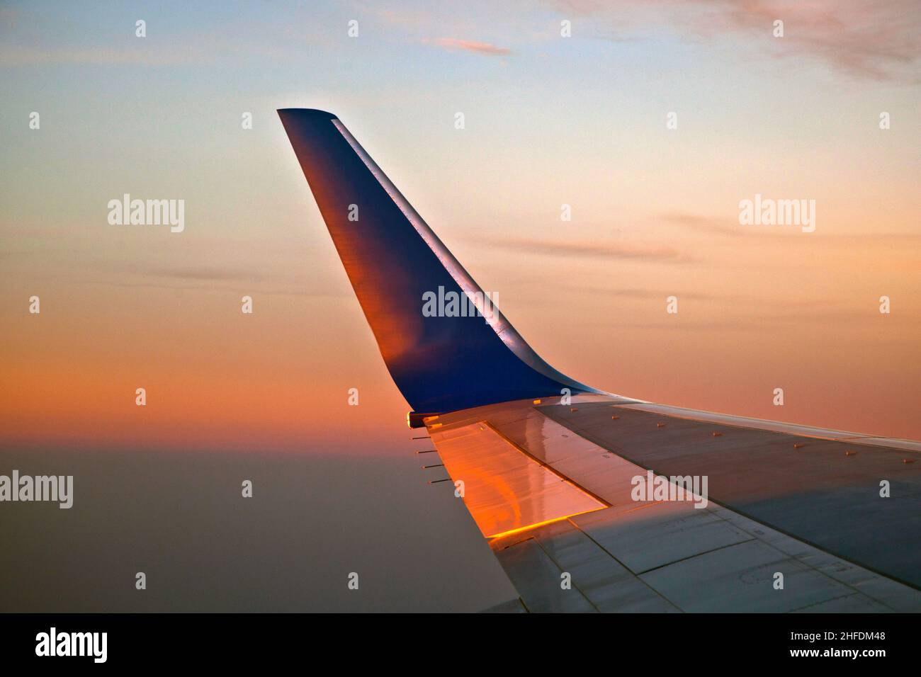 wing of passenger aircraft in spectacular sunset Stock Photo - Alamy