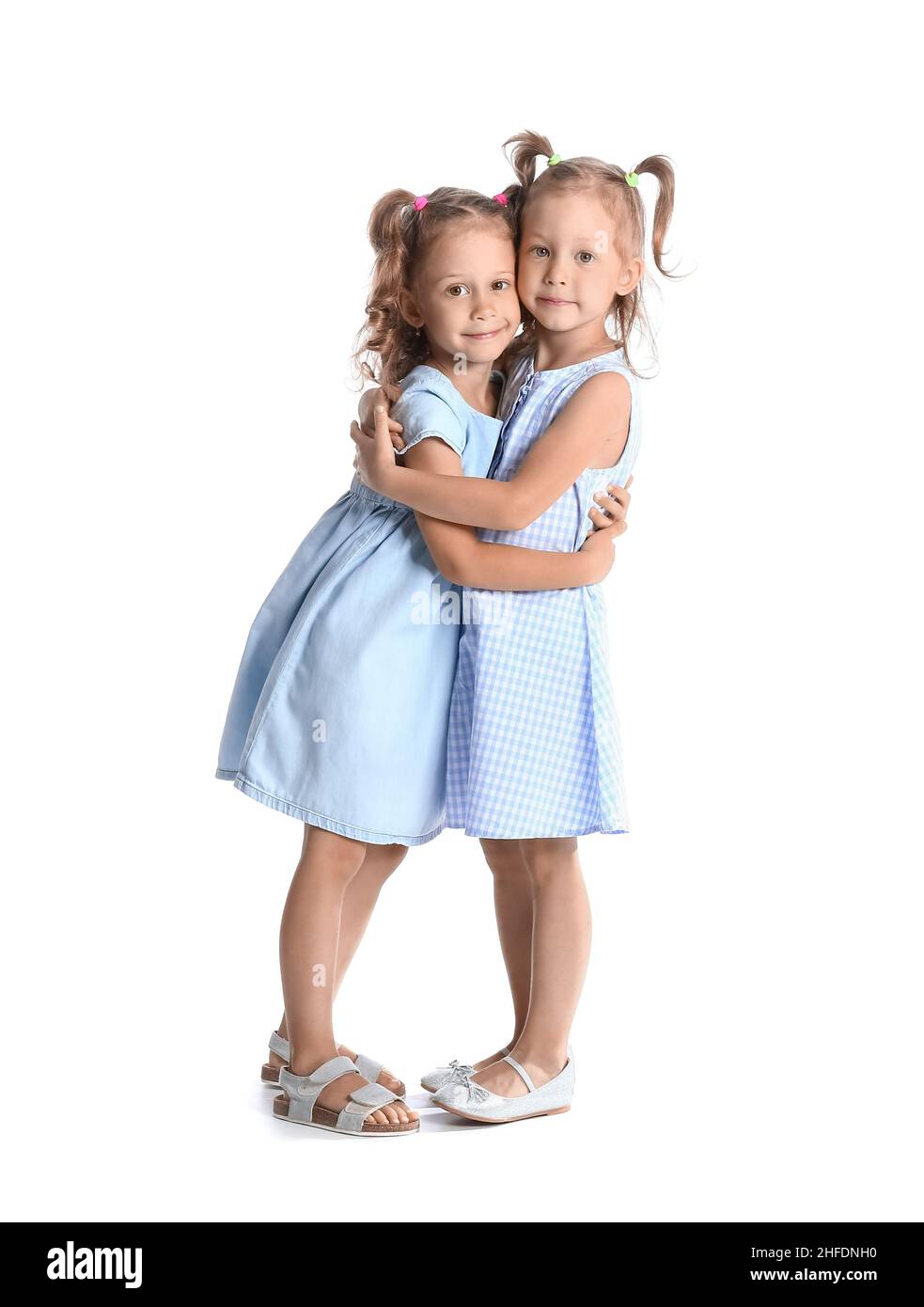 Adorable little sisters hugging on white background Stock Photo - Alamy