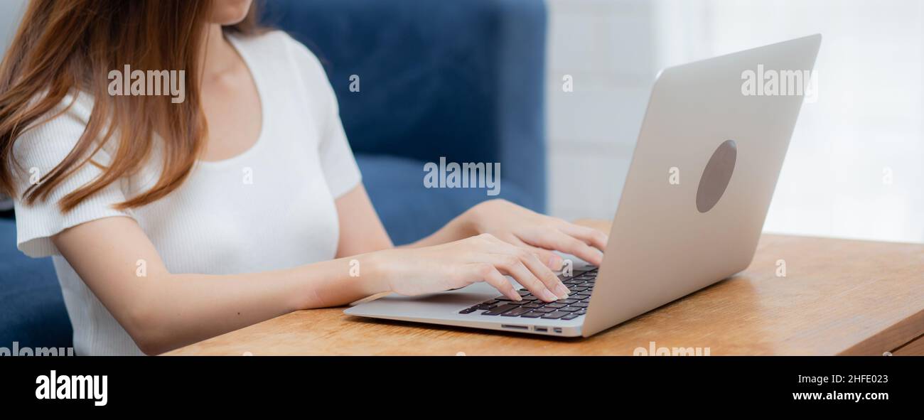 Beautiful young asian woman typing keyboard on laptop computer on desk ...