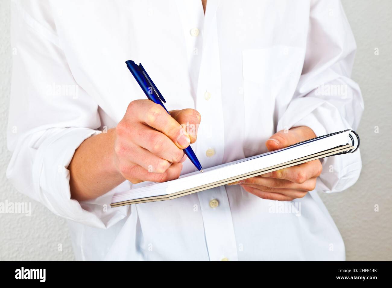 man writing in a book Stock Photo - Alamy