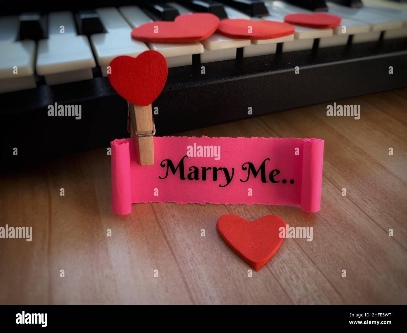 Marry me label on pink paper with heart shape and keyboard background ...