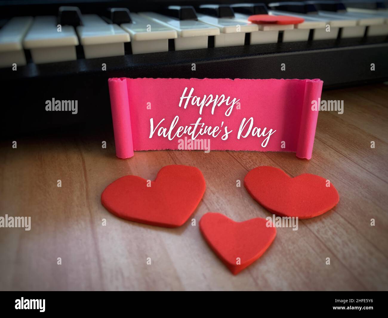 Happy Valentine's day label on pink paper with heart shape and keyboard ...