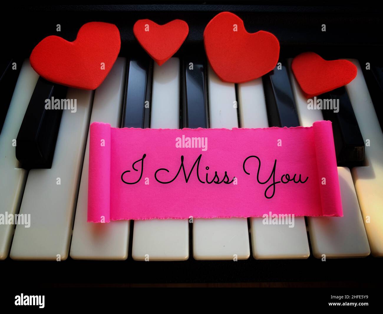 I miss you text on a small torn paper with keyboard and heart shape ...