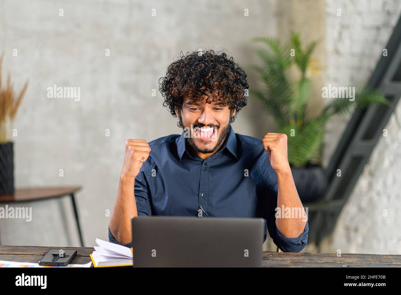 Excited Pakistani businessman looking at the laptop screen and ...