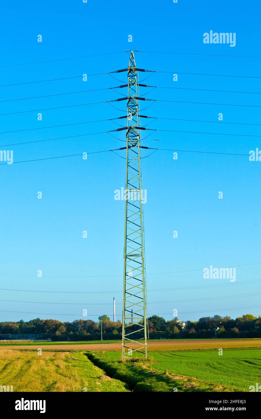 electrical tower in field under blue sky Stock Photo - Alamy