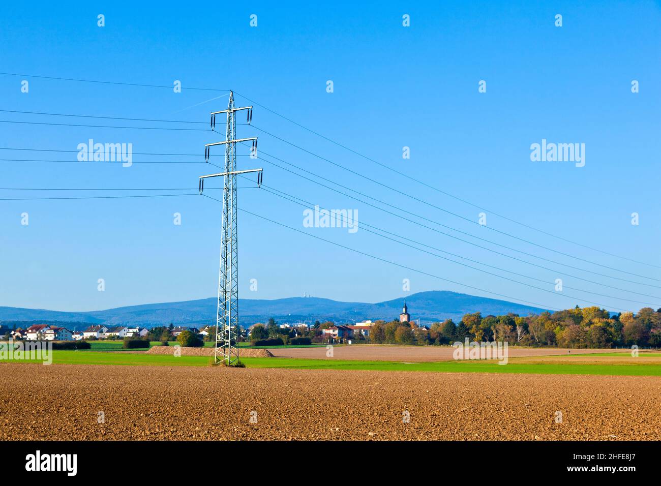 electrical tower in field under blue sky Stock Photo - Alamy