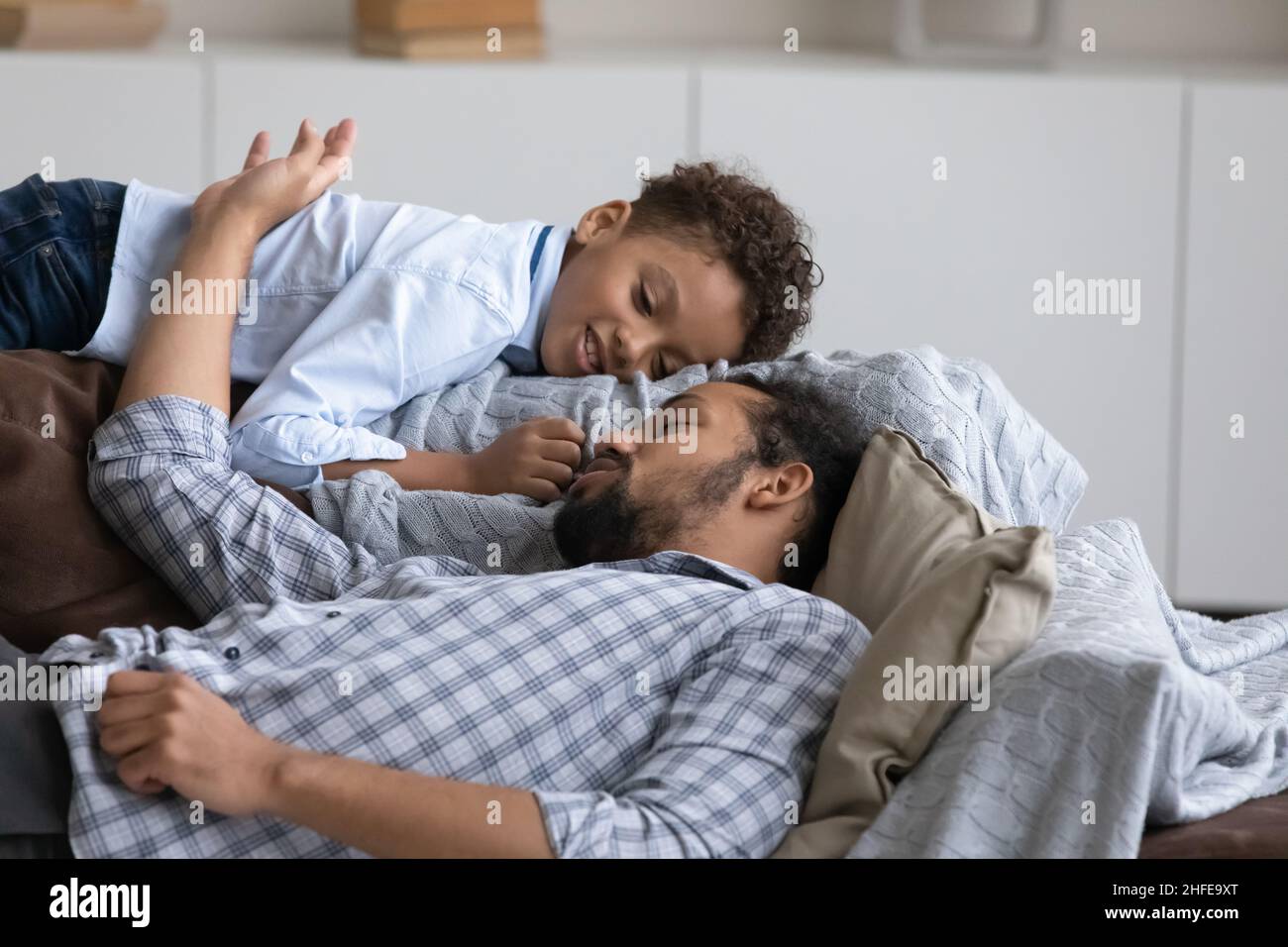Calm happy dad and son boy resting, sleeping on sofa Stock Photo - Alamy
