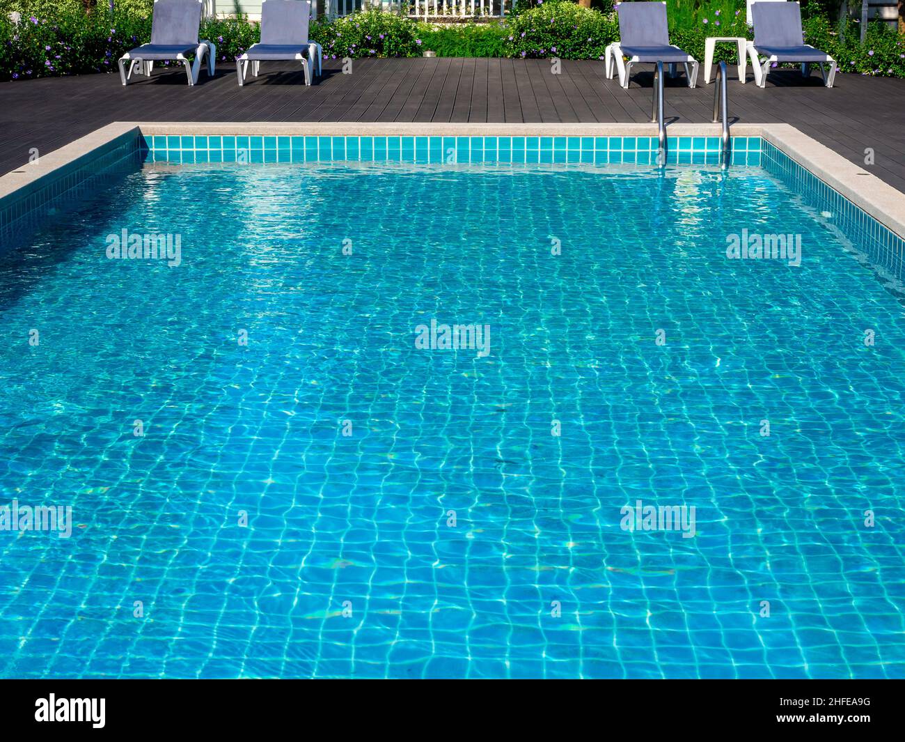 Swimming pool with clean clear water, nobody. Square shaped pool with ...