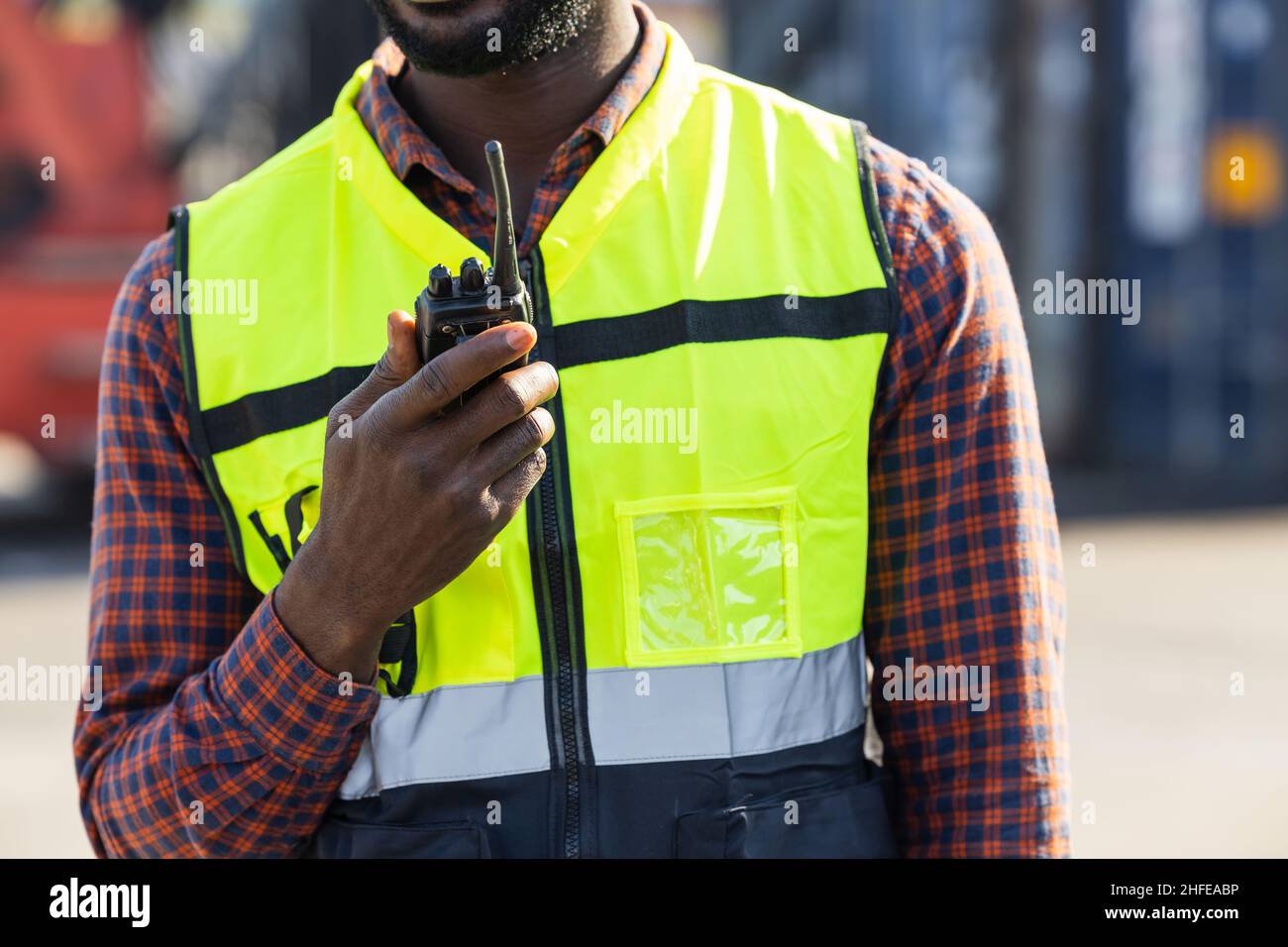 closeup worker using ham radio for operation control in cargo port ...