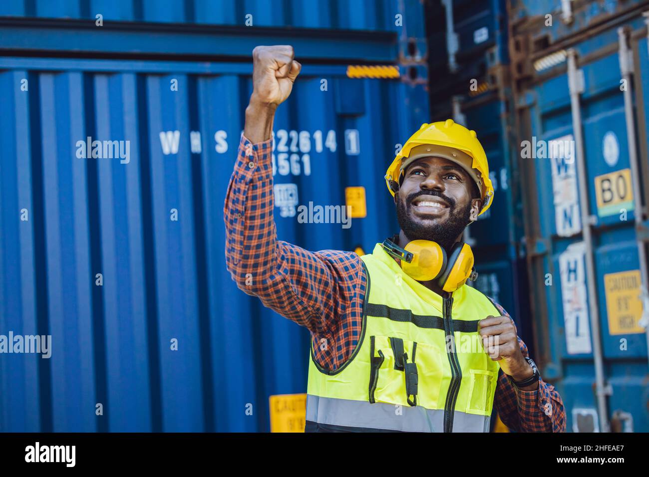 African Black staff worker happy smile rising hand to fight in cargo ...