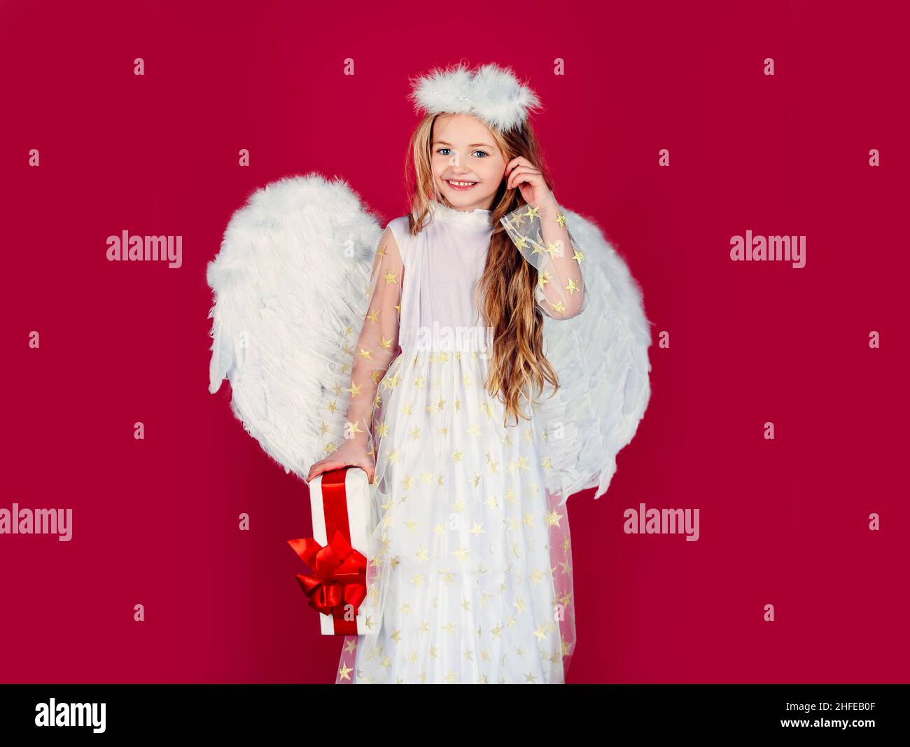 Kid girl angel with present gift, studio portrait. Little angel with ...