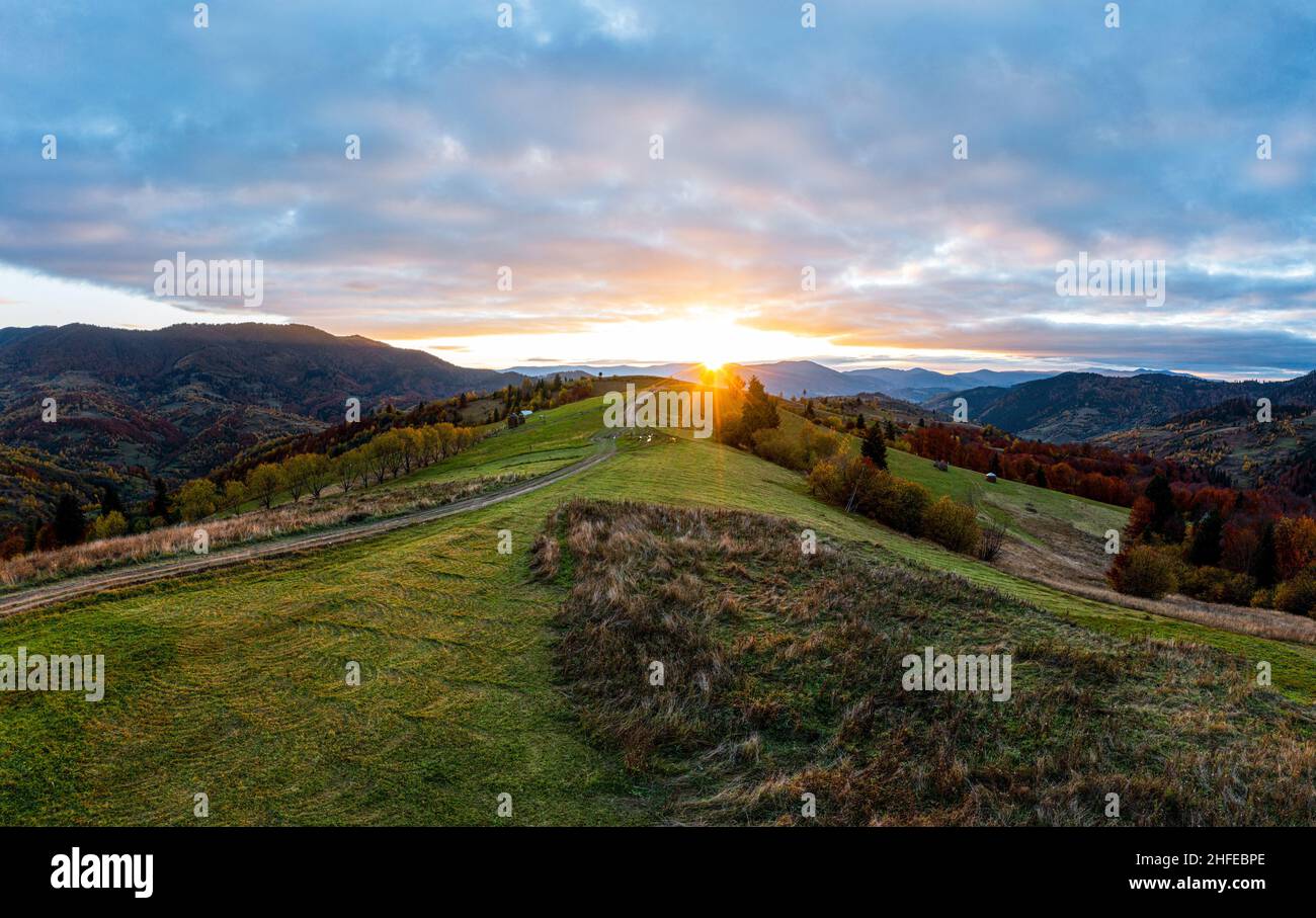 Long narrow path leading to high mountain peak across broad green ...