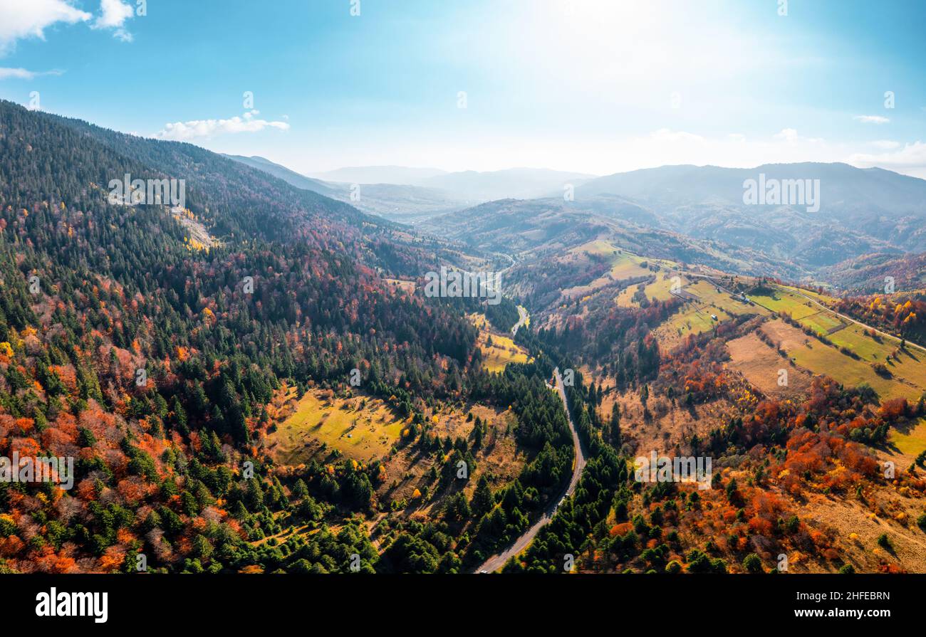 High mountain peak with green and red-colored forests and colorful ...