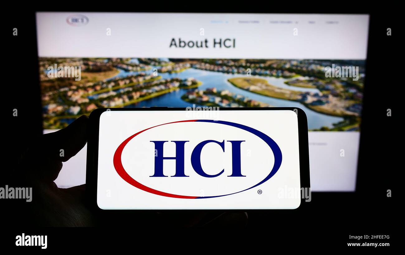 Person holding mobile phone with logo of American insurance company HCI ...
