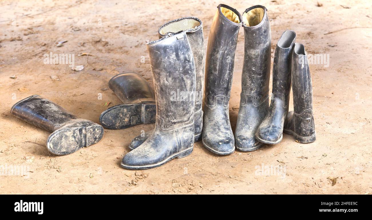 dirty plastic riding boots standing at the muddy gry ground Stock Photo ...