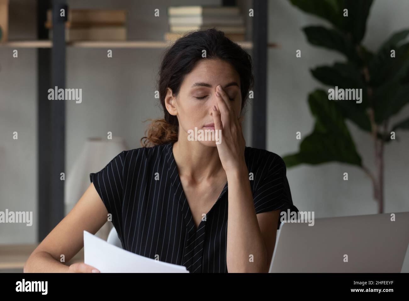 Confused young woman feeling stressed of reading letter with bad news ...