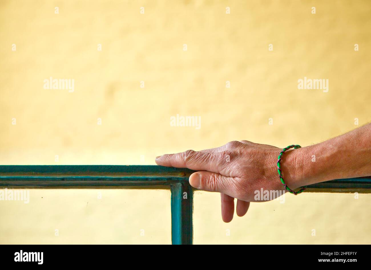 hand with bracelet leaning on a window frame Stock Photo - Alamy