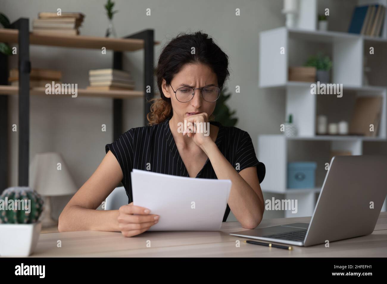 Worried unhappy young woman reading paper letter with bad news Stock ...
