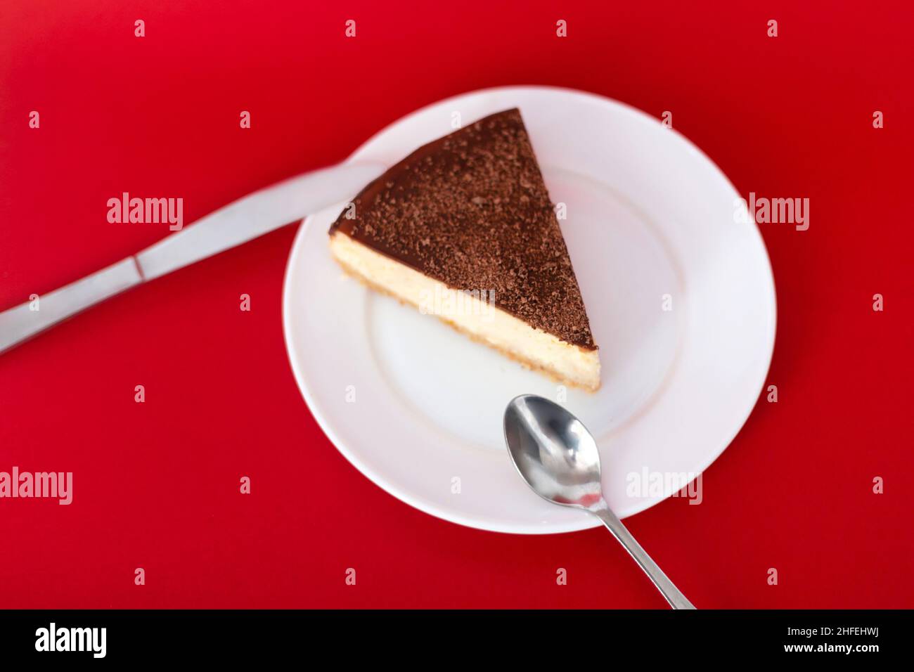 Cheesecake on a plate with cutlery, serving on a red background Stock ...