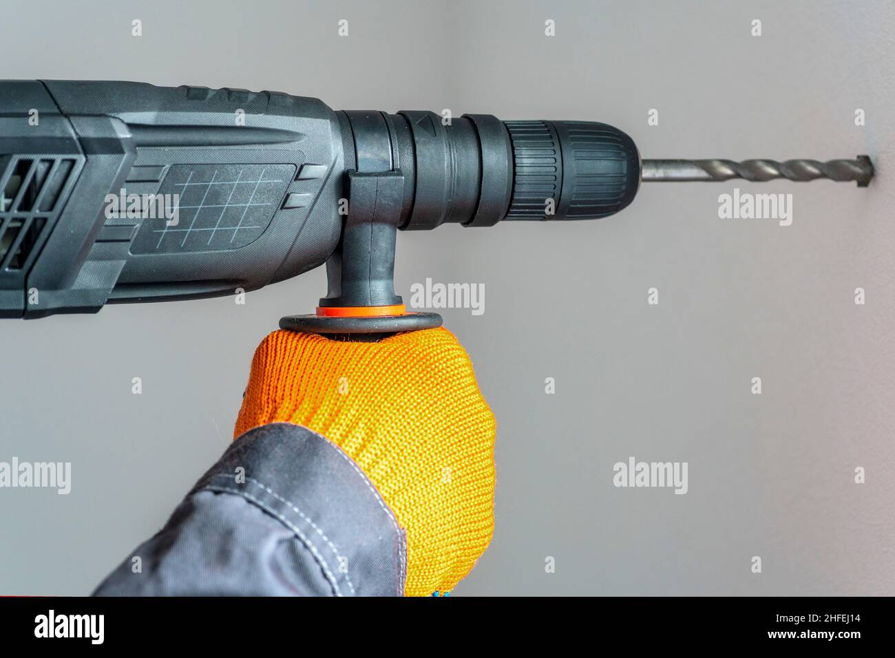 workman hand with a rotary hammer. Hands in protective gloves with ...