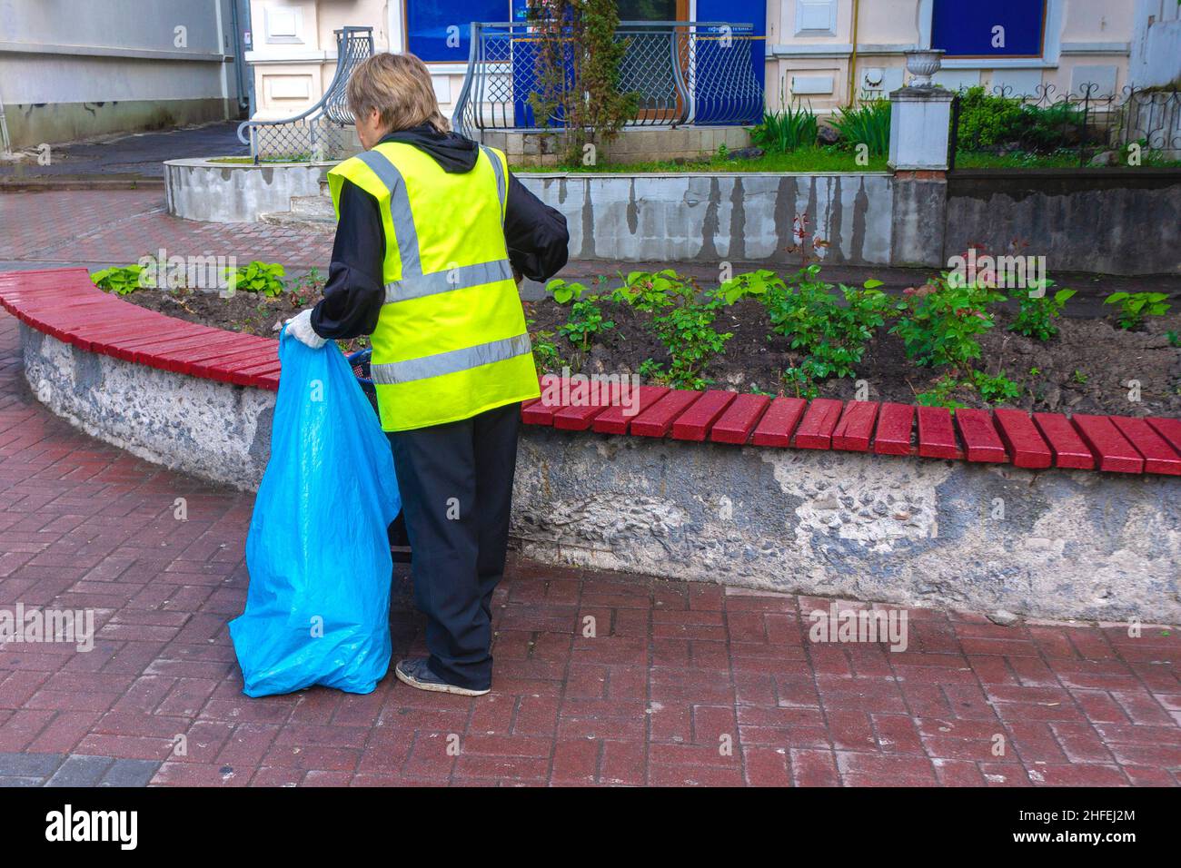 woman the cleaner collects garbage . sanitation worker sweep street ...