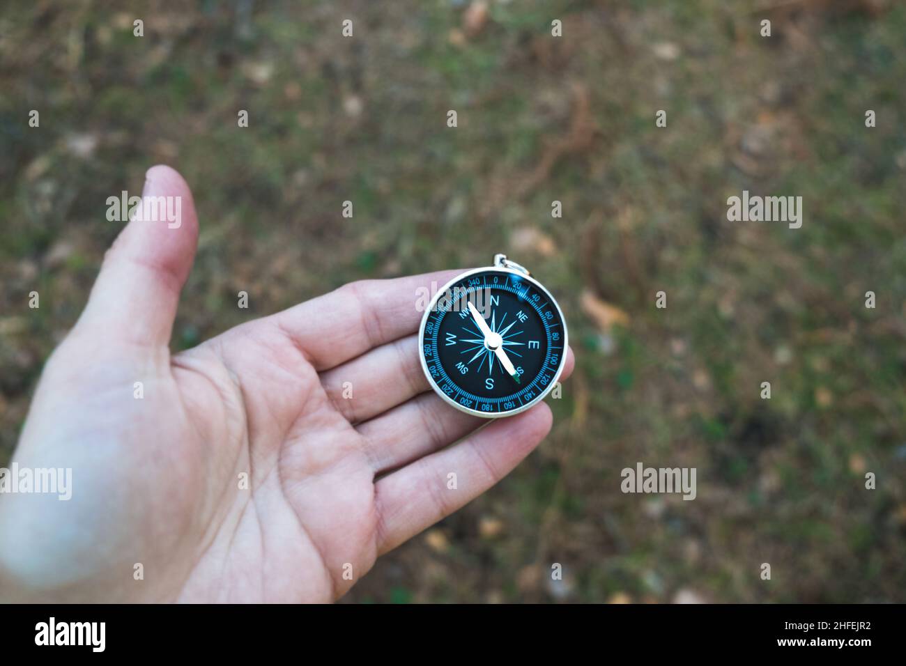 a hand holding a compass seeking orientation in an unfamiliar place ...