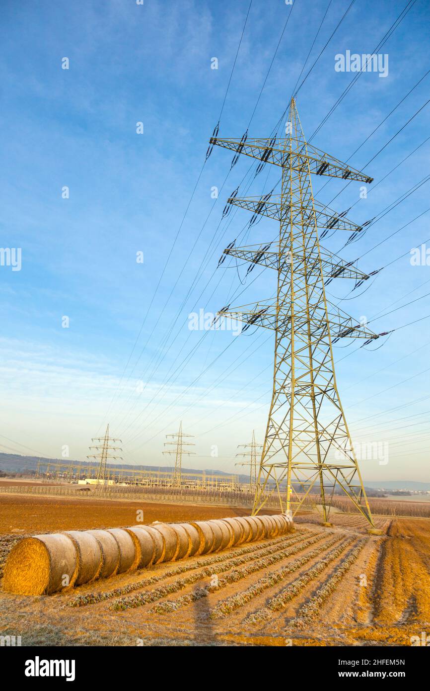 electrical tower in rural landscape with bale of straw Stock Photo - Alamy