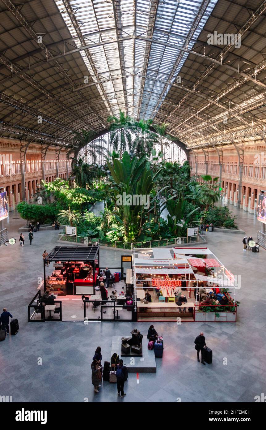Madrid- Puerta de Atocha Train Station . Steel and glass construction with vivid tropical garden ...
