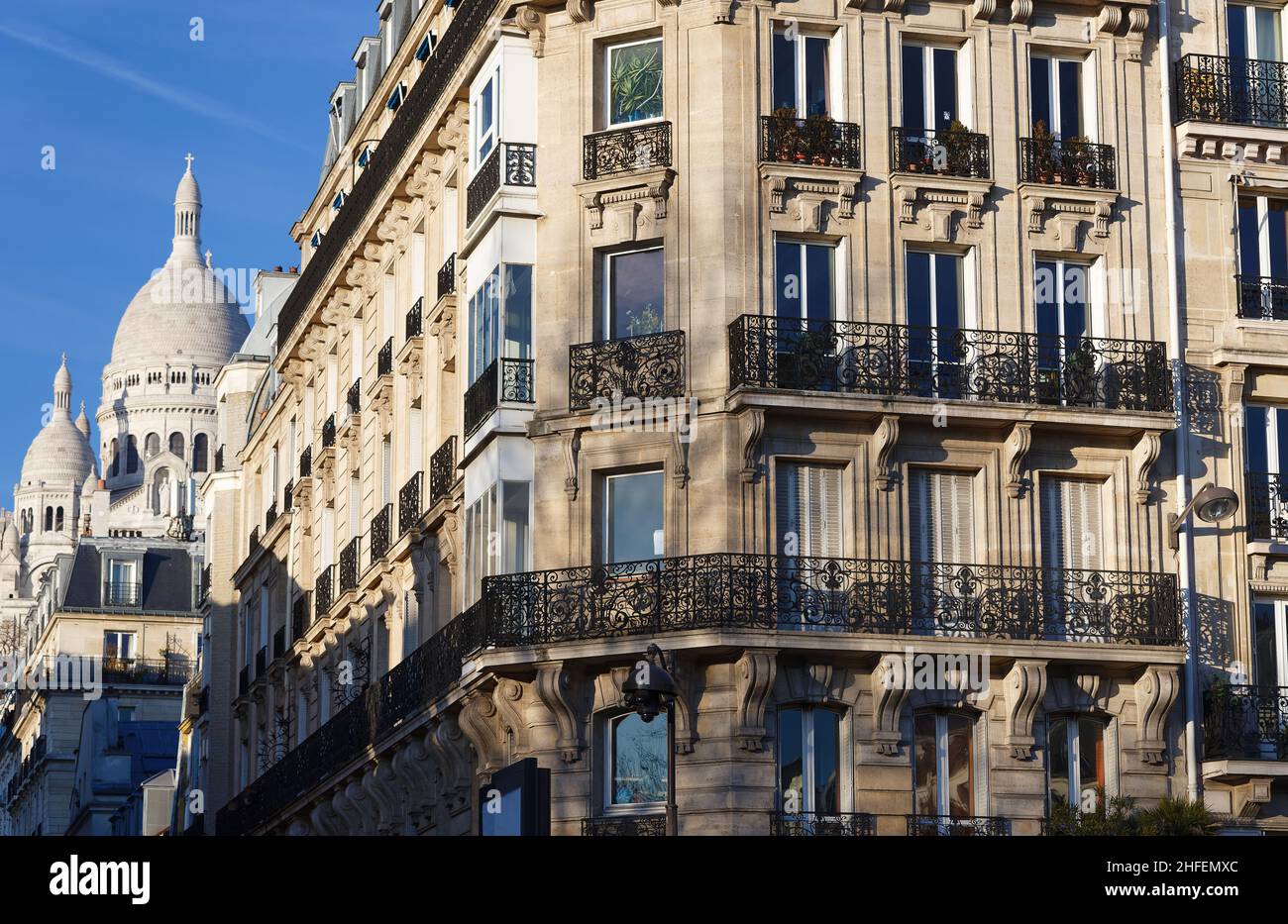 The facade of traditional Parisian building and Sacre Coeur basilica in ...