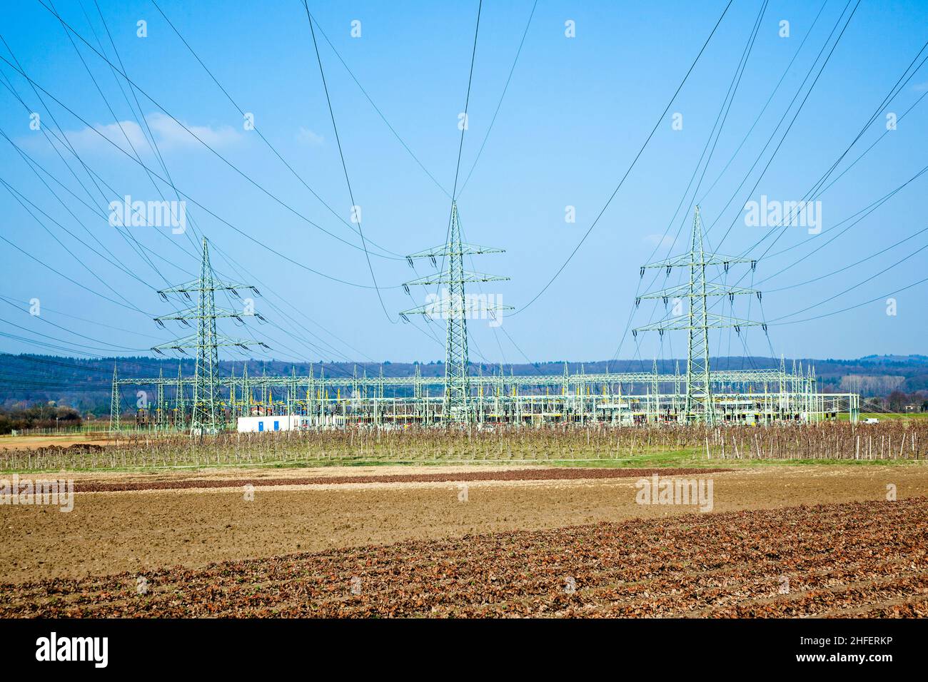 landscape with electric masts and transformer station under blue sky ...