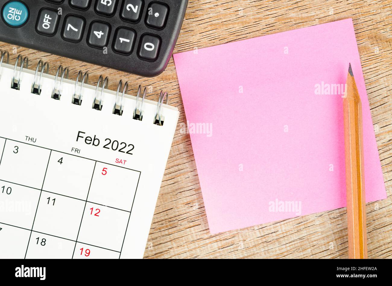 Blank sticky note on February 2022 desk calendar on wooden background ...