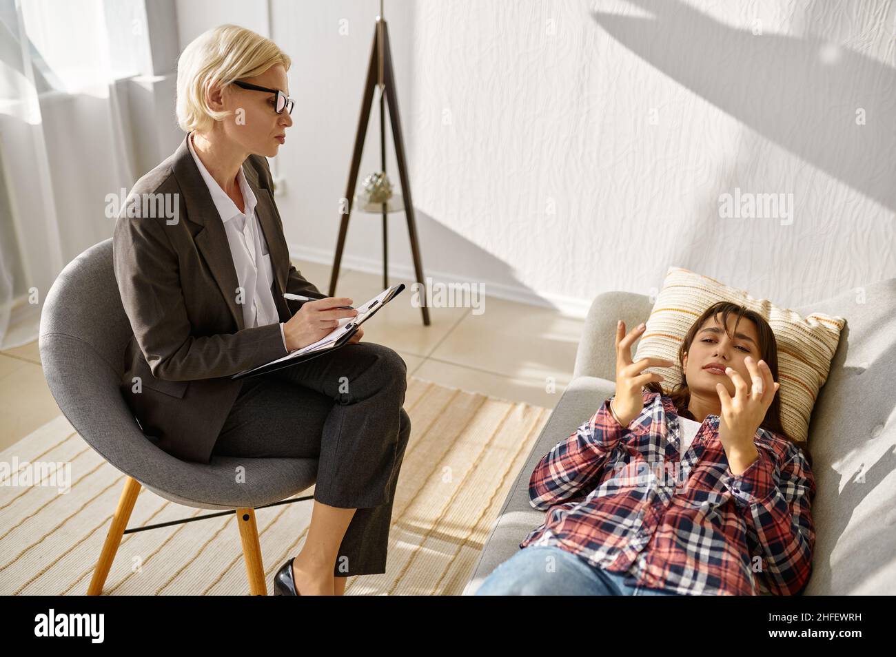 Female psychologist working with woman on couch Stock Photo - Alamy