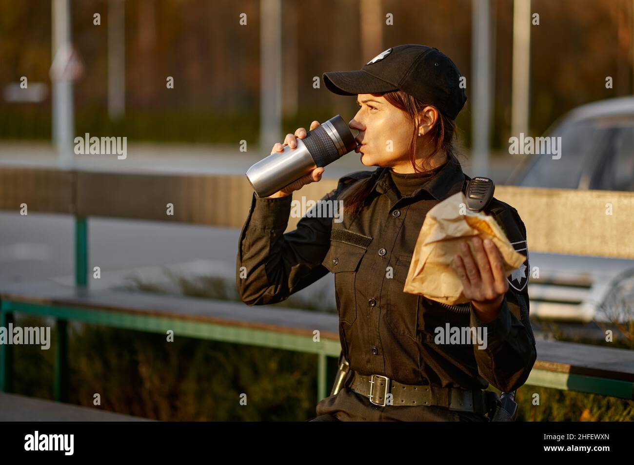 Police woman take break eating in park Stock Photo - Alamy