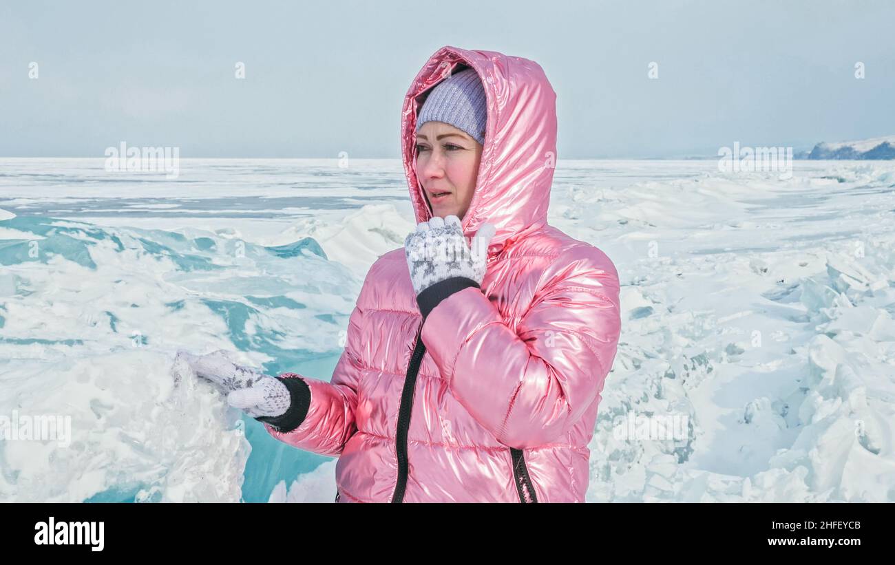 Girl walking on cracked ice of frozen lake Baikal. Woman traveler ...