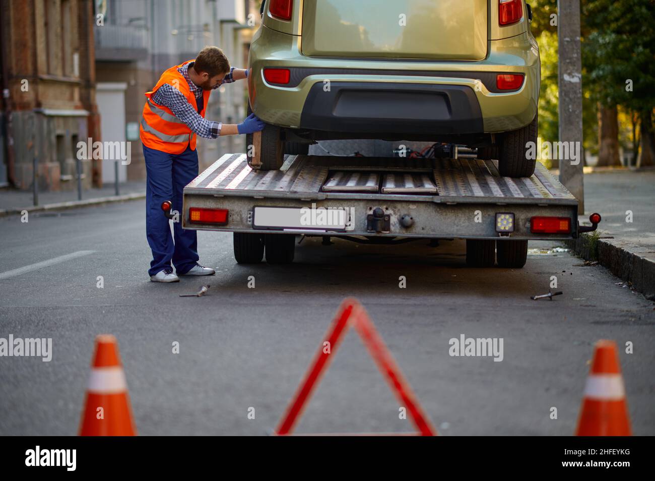 Warning triangle and traffic cone on road Stock Photo - Alamy