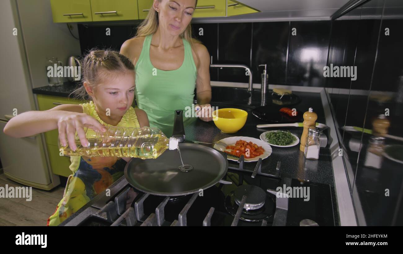 Mother teaching daughter smart girl learning to cook. Young mistress ...